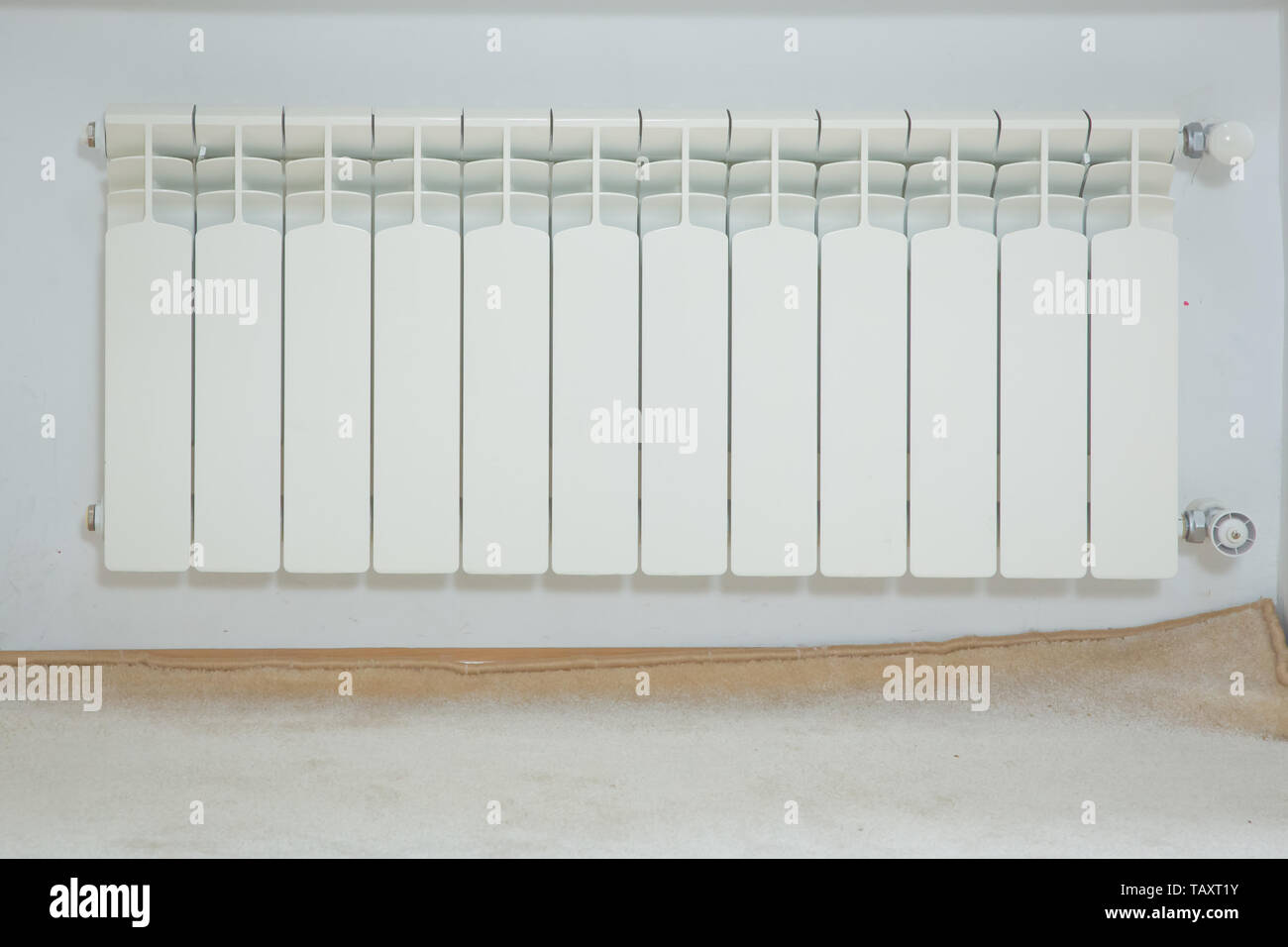 Interior detail. White metal radiator on a white wall. Central heating ...