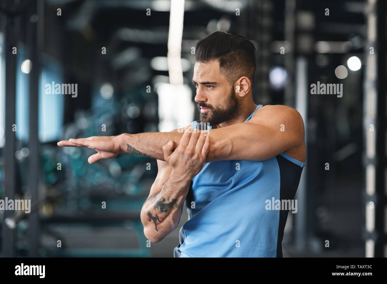 Sporty man at gym doing stretching exercises for hands Stock Photo - Alamy