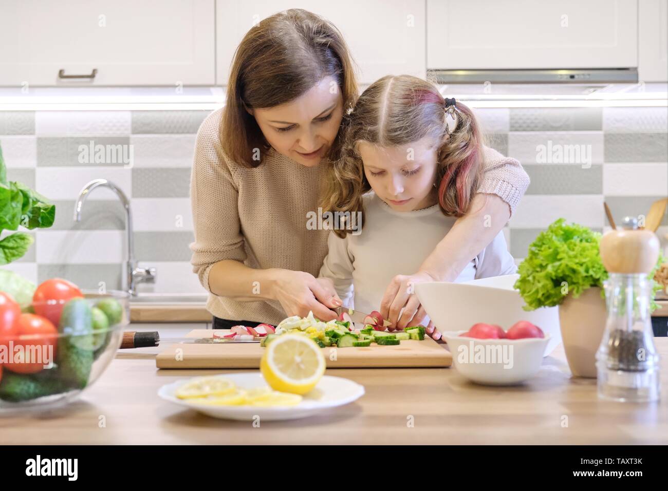 Mother and child cooking together at home in kitchen. Healthy eating ...