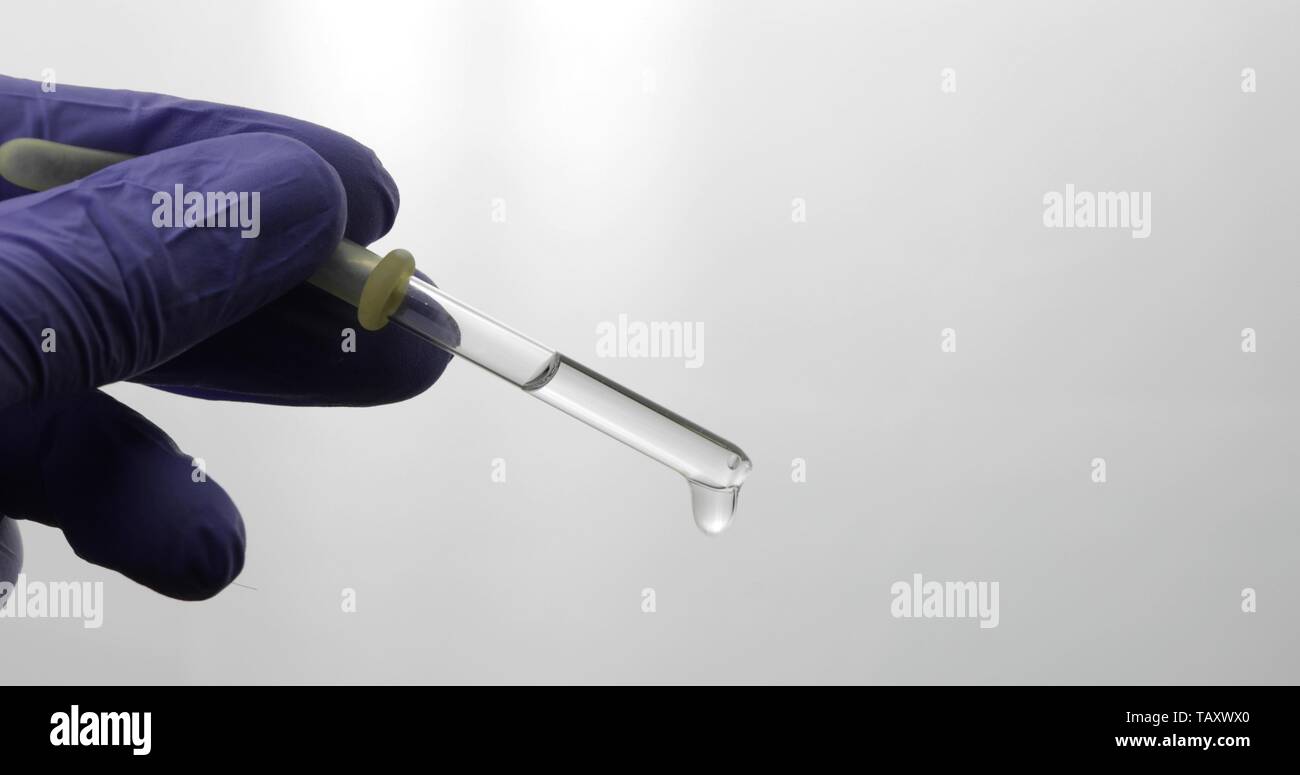 Hand in medical glove drip drop from pipette. Close-up video. Liquid ...