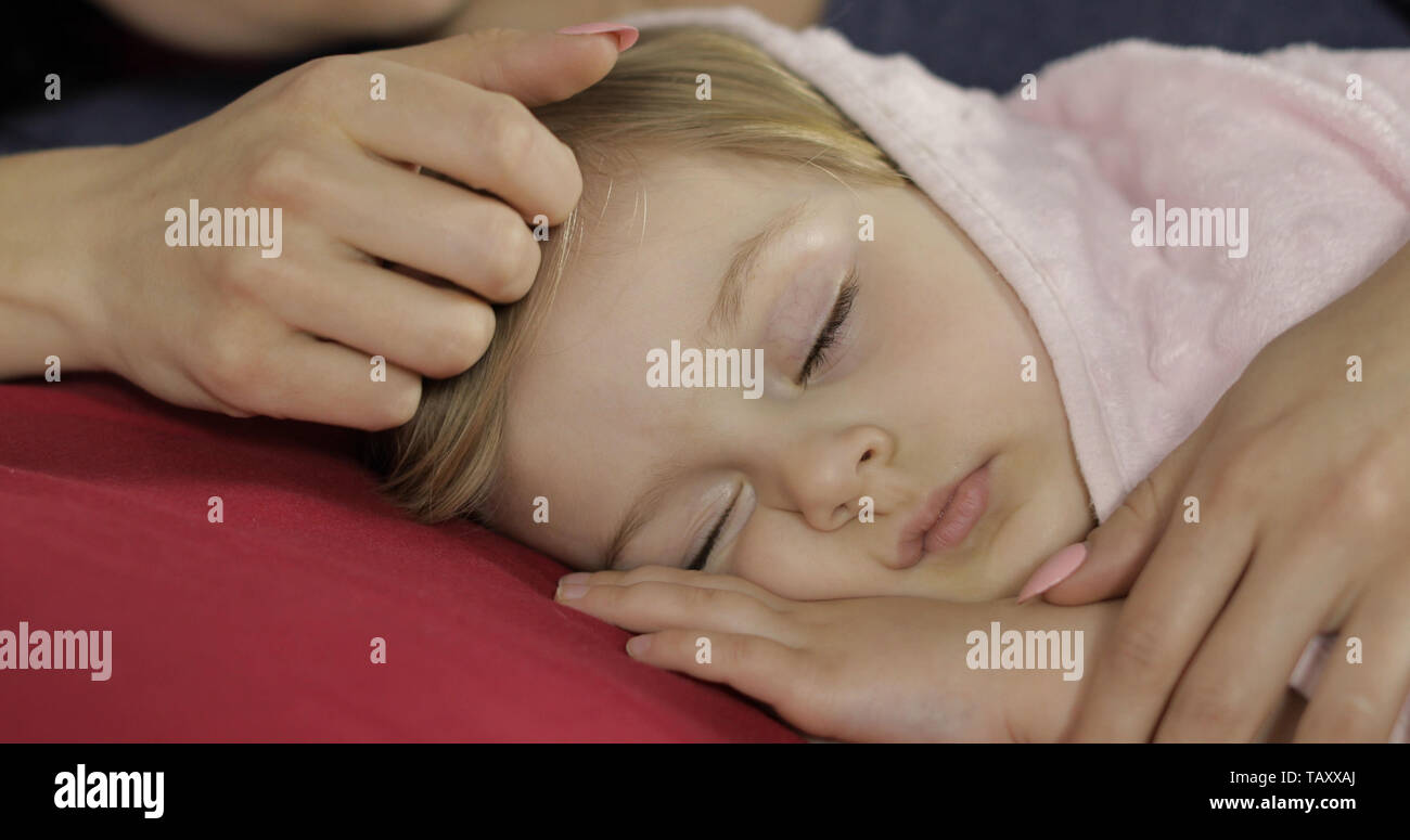 Young mother taking care of her little baby girl while she sleep. Girl ...