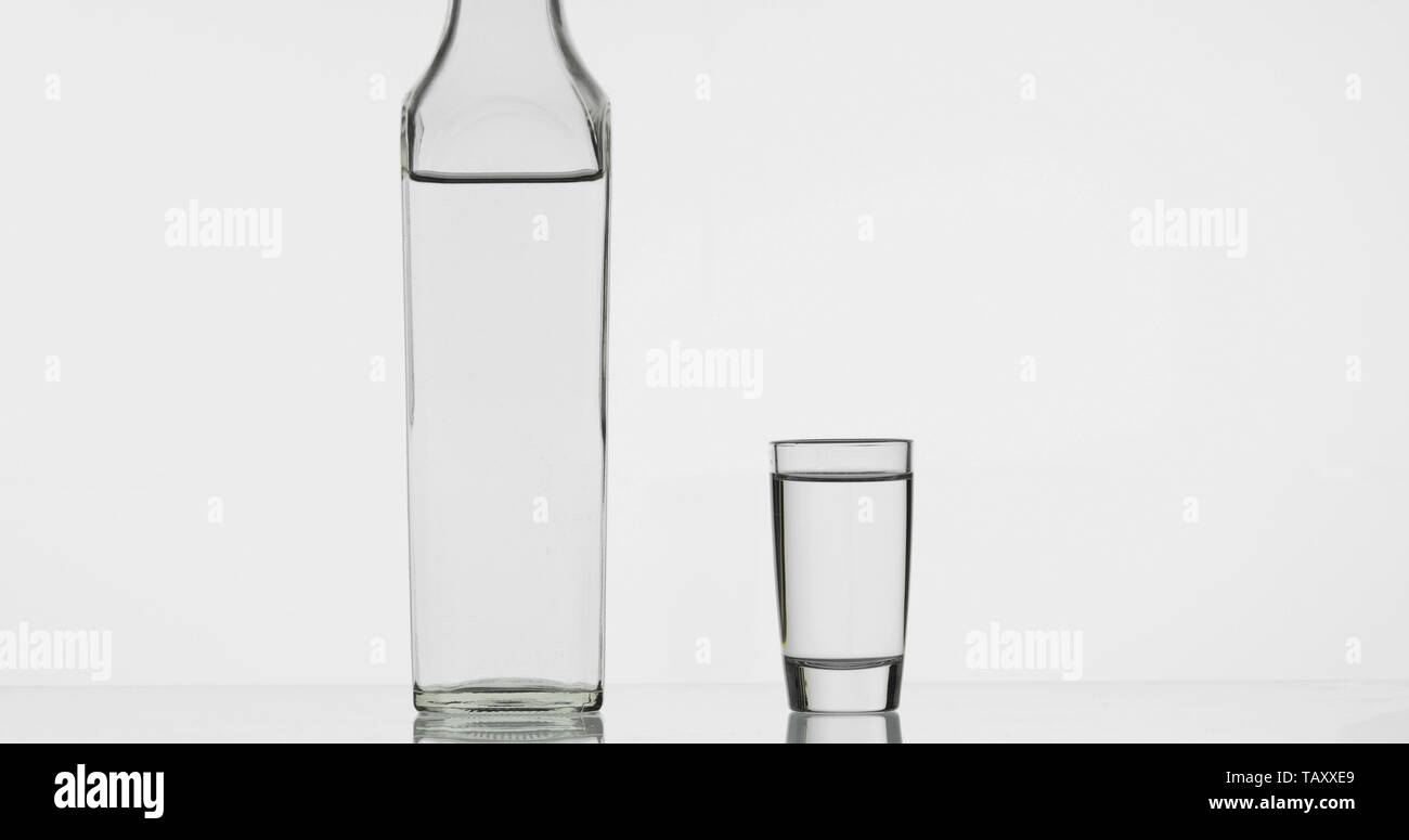 Shot of vodka in glass and bottle. White background. Alcohol drink ...