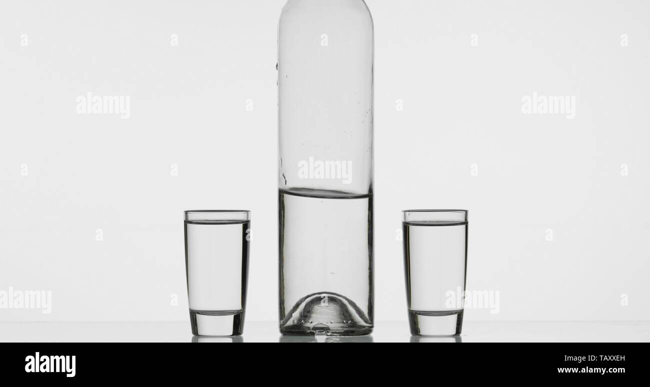 Two shots of vodka in glasses and bottle. White background. Alcohol ...