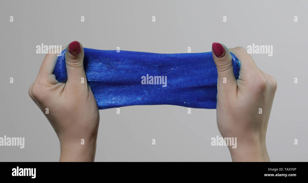 Woman hands playing with oddly satisfying blue slime sticky gooey ...