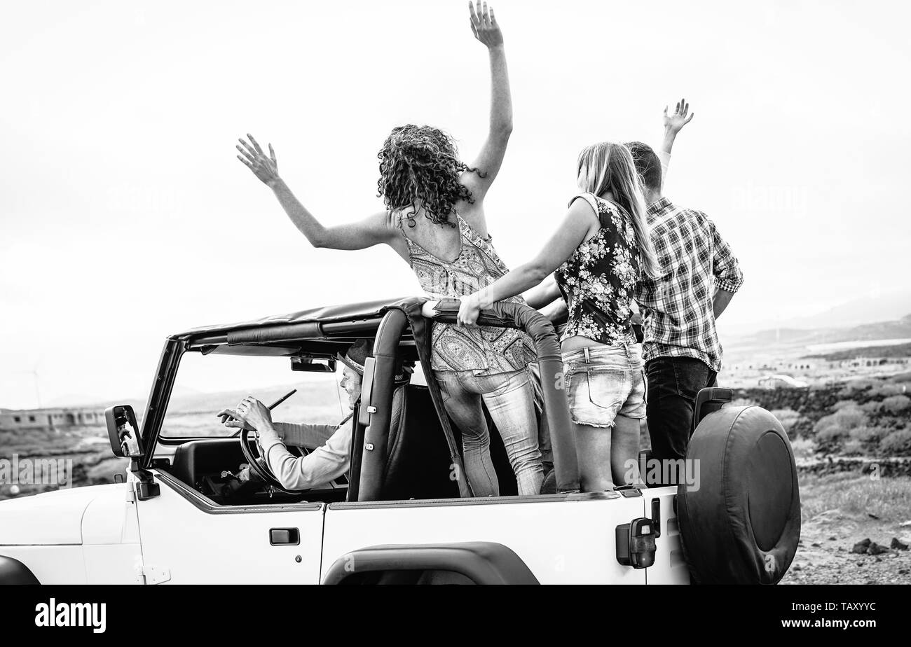 Group of friends driving off road convertible car during roadtrip ...