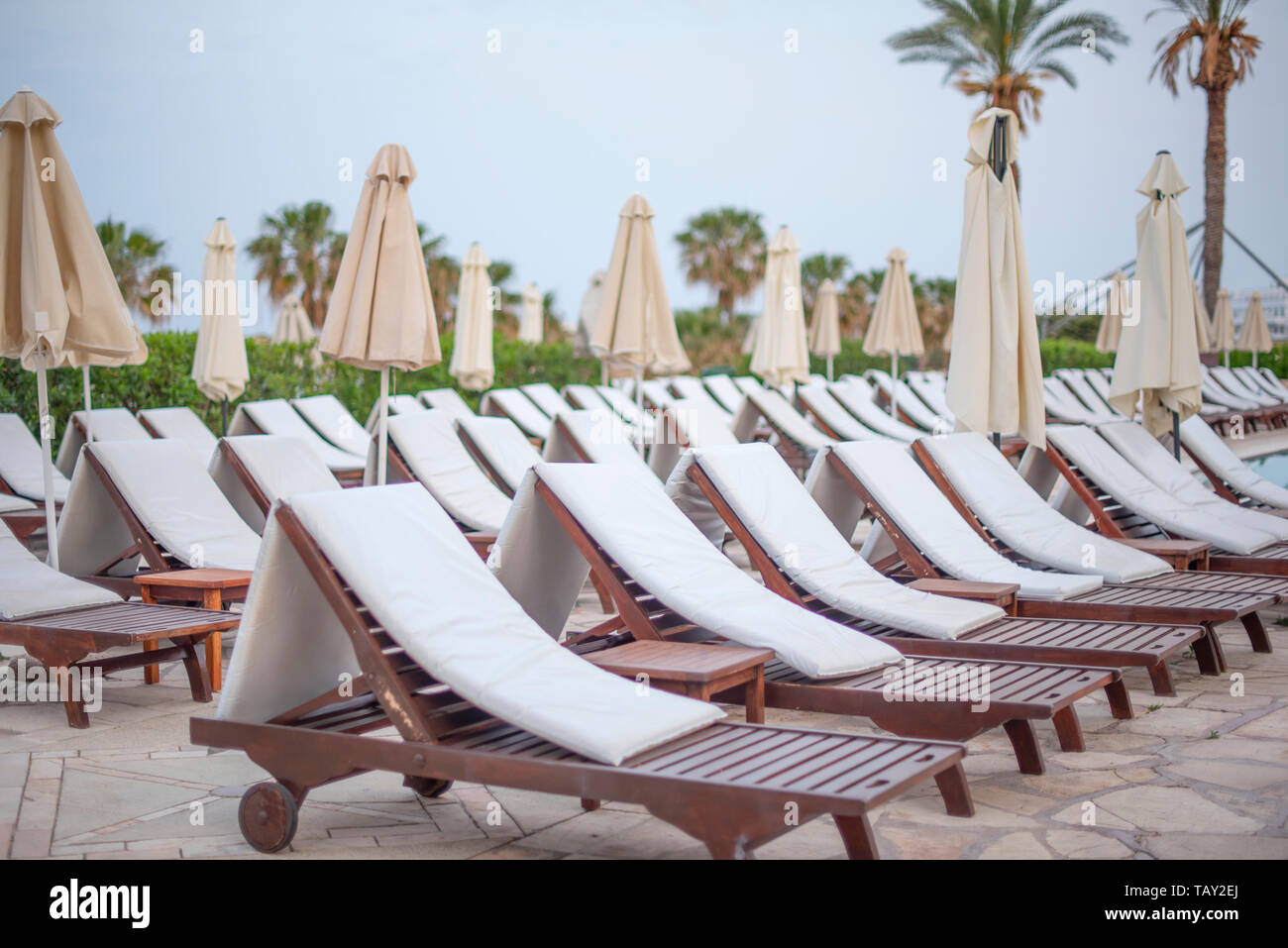 wooden sun beds and umbrellas Stock Photo - Alamy