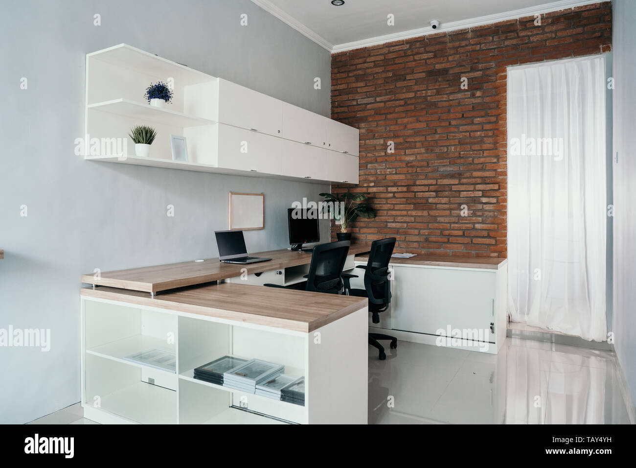 computer and laptop in comfortable work space inside a clean and tidy ...