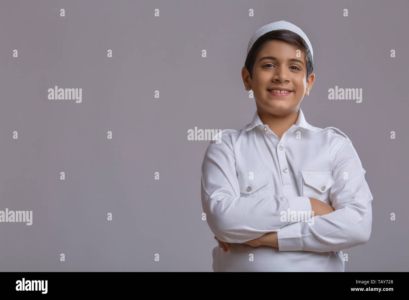 young Muslim boy wearing cap folding hands and smiling Stock Photo - Alamy