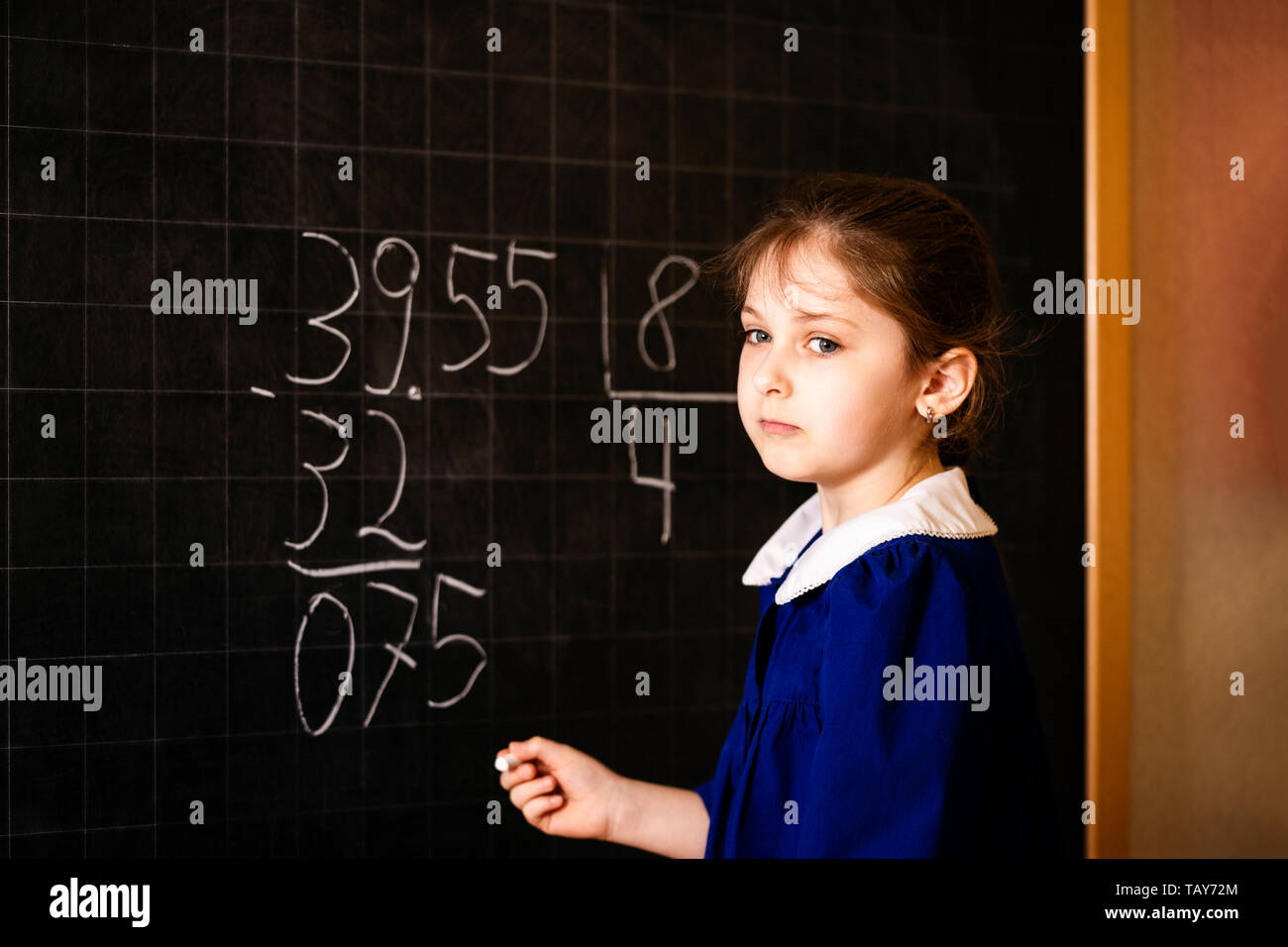 Italian elementary school girl trying to make a long division. The ...