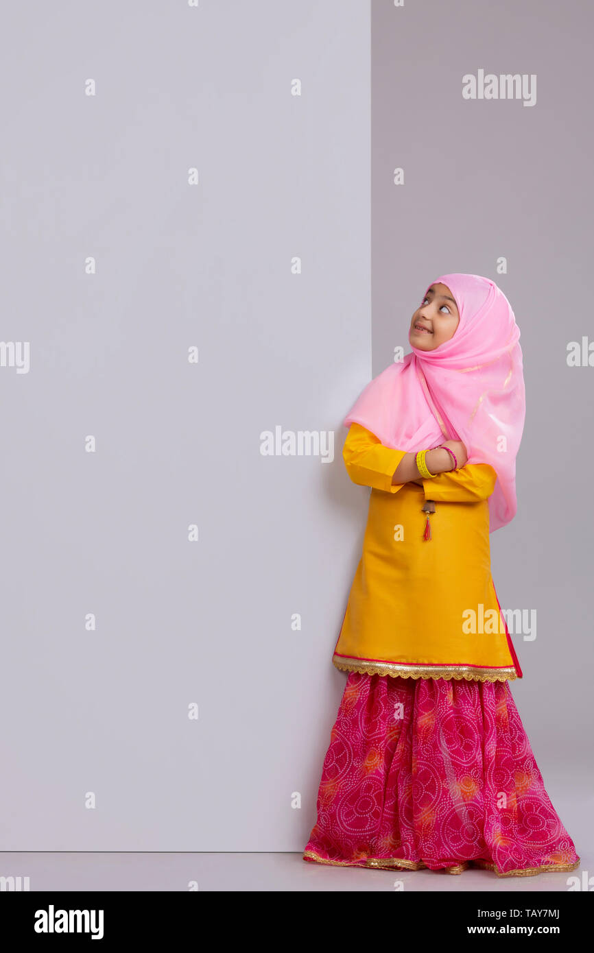 young Muslim girl with hijab folding hands and looking up Stock Photo ...