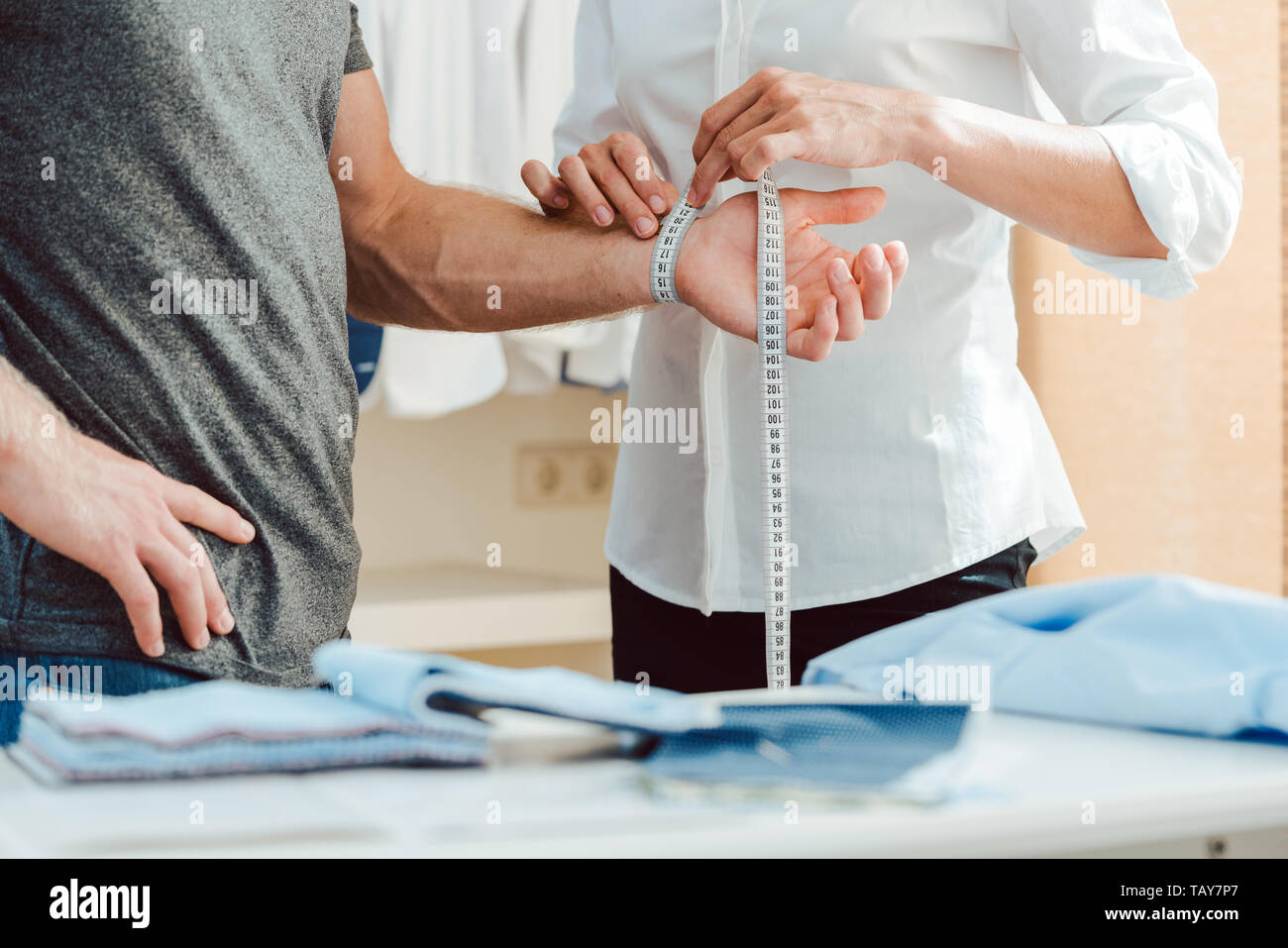 Tailor measuring customer with measuring tape Stock Photo - Alamy