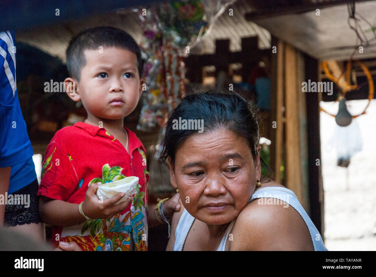 Mekong river, Laos - Feb 2016: Portrait of a child eating pomelo and ...