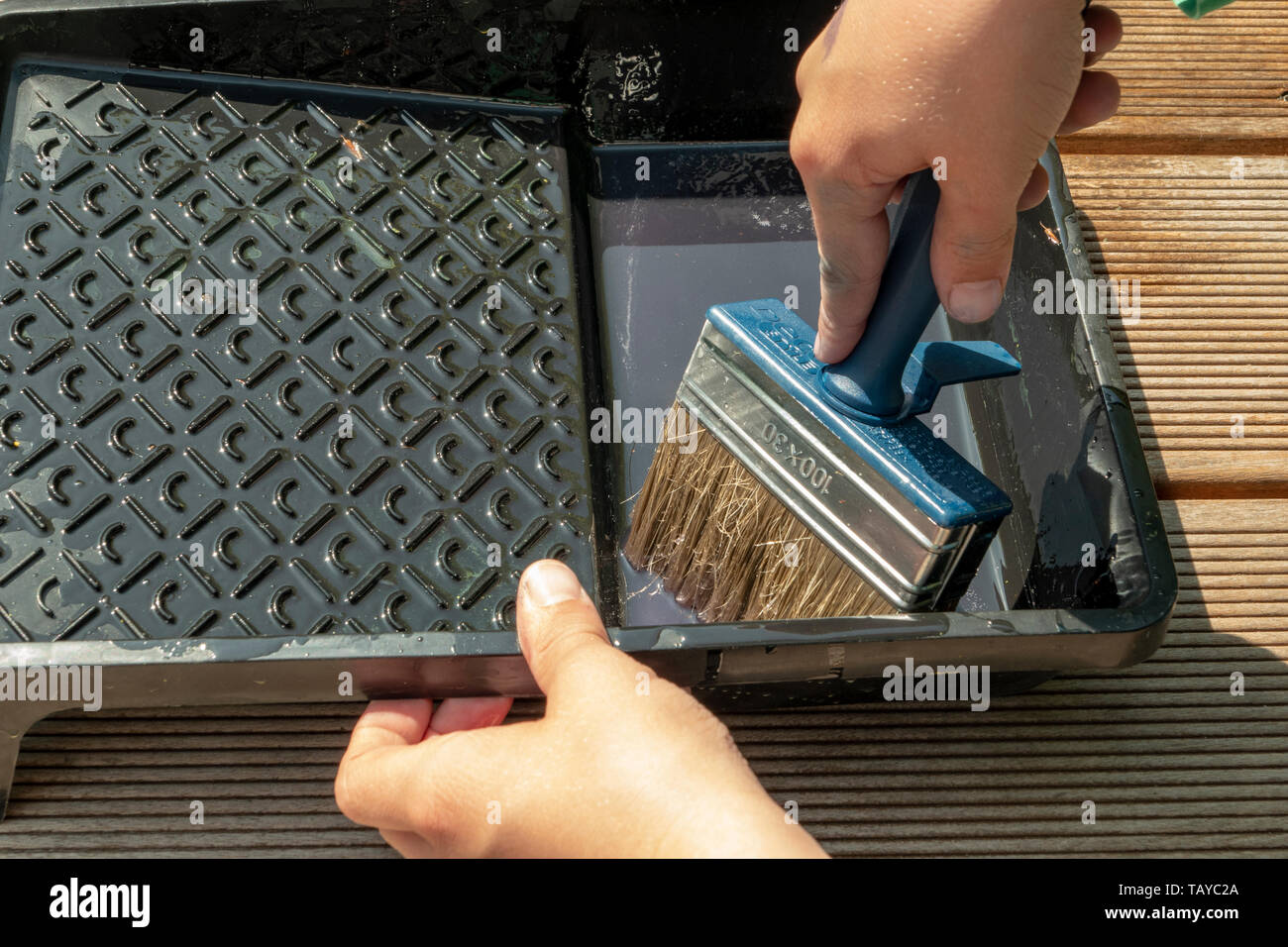Hands with large brush dip in glaze to paint the terrace Stock Photo ...
