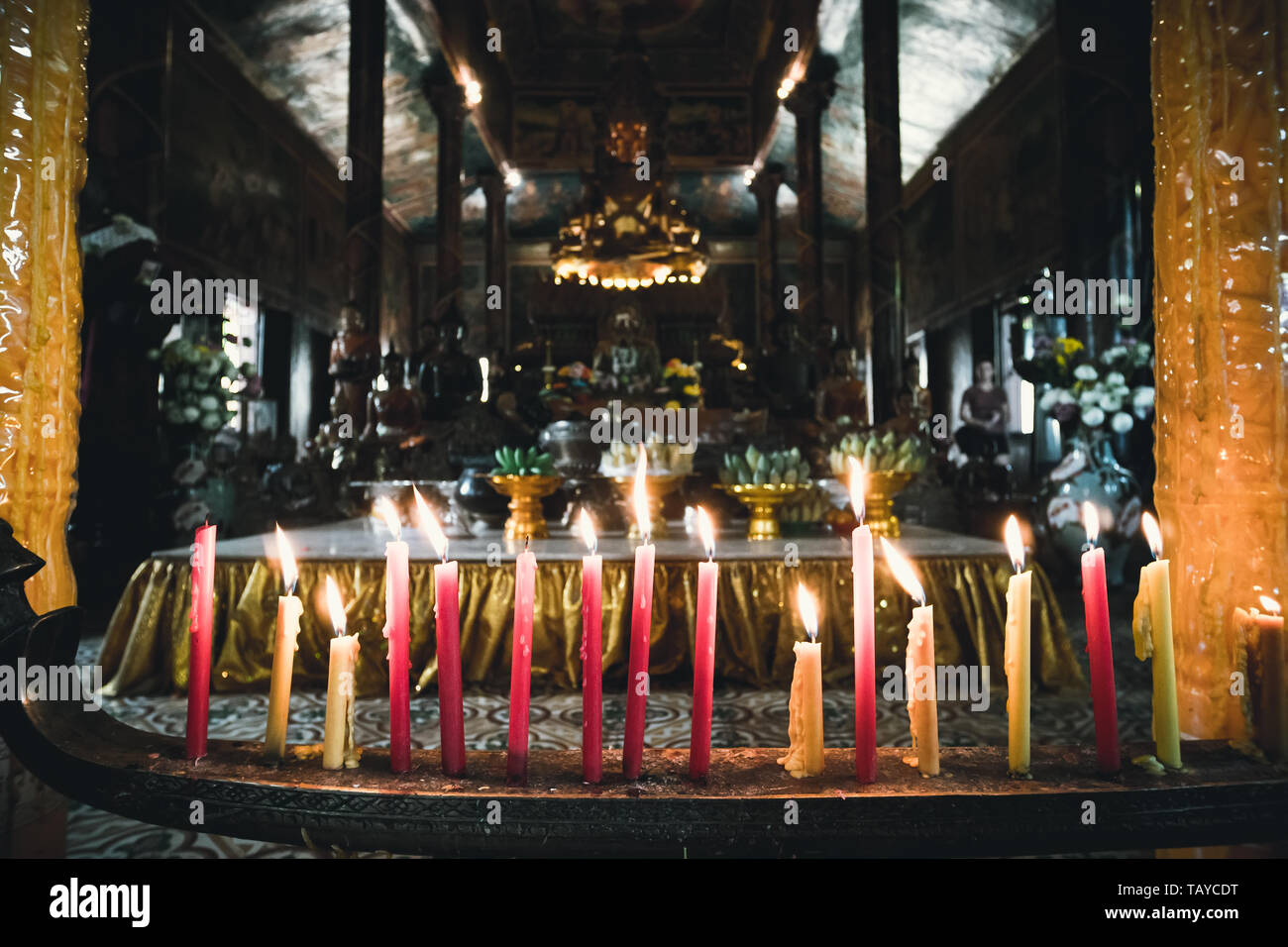 Candlelight form prayer in the temple. Colorful candles in a Buddhist ...