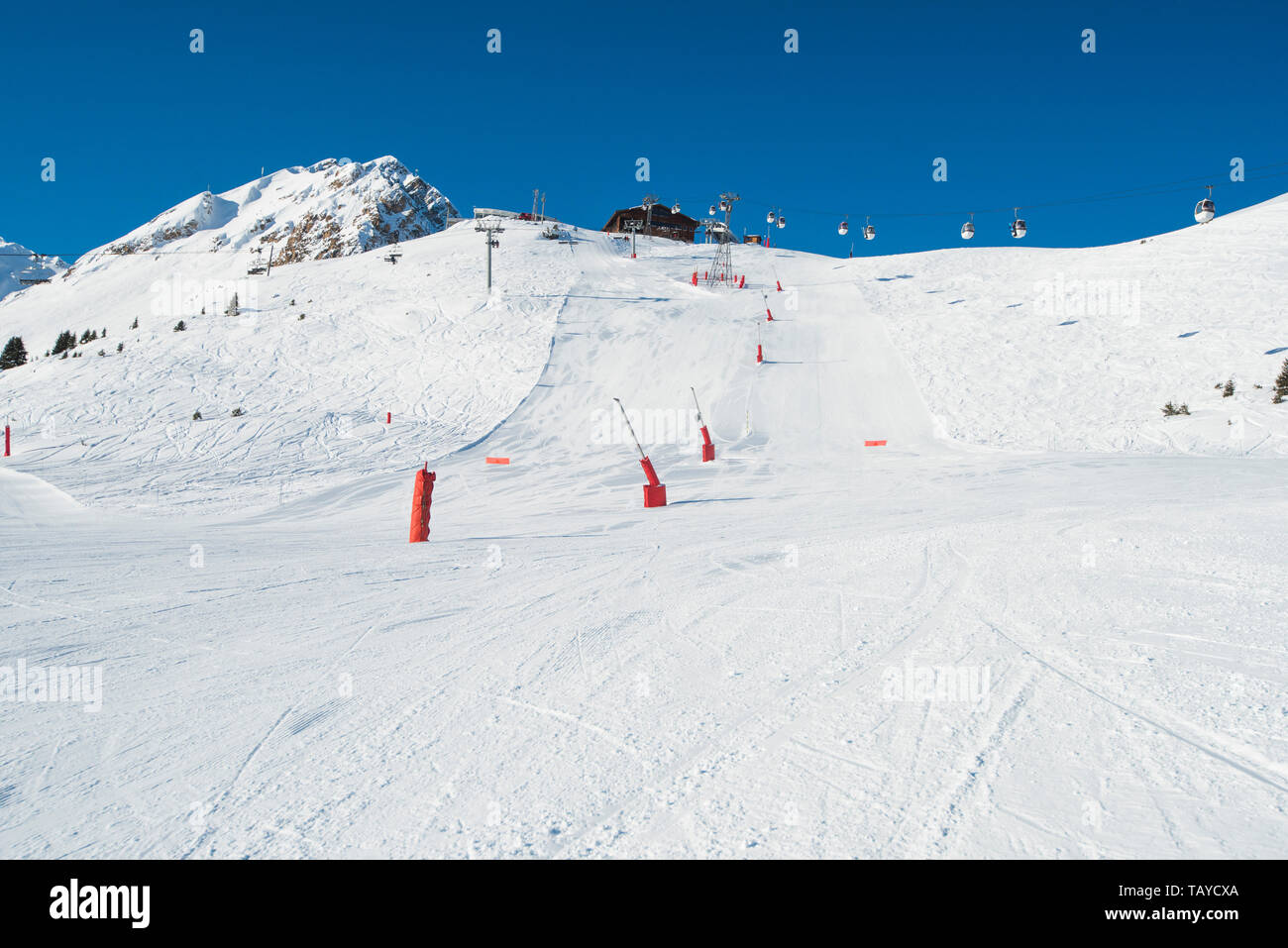 Panoramic landscape up a large ski slope piste in winter alpine ...