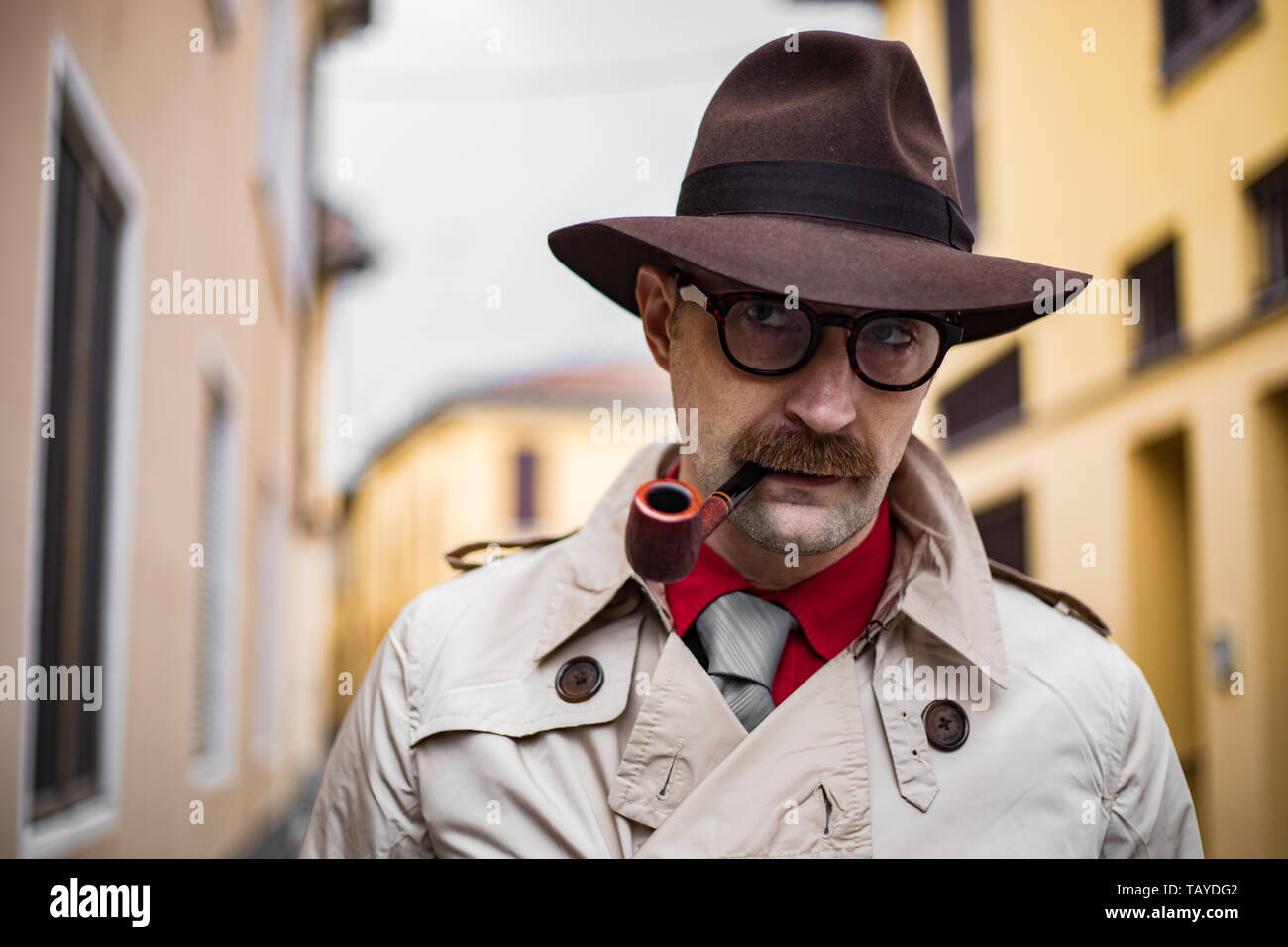 Vintage detective smoking a pipe outdoor in a grungy environment Stock ...