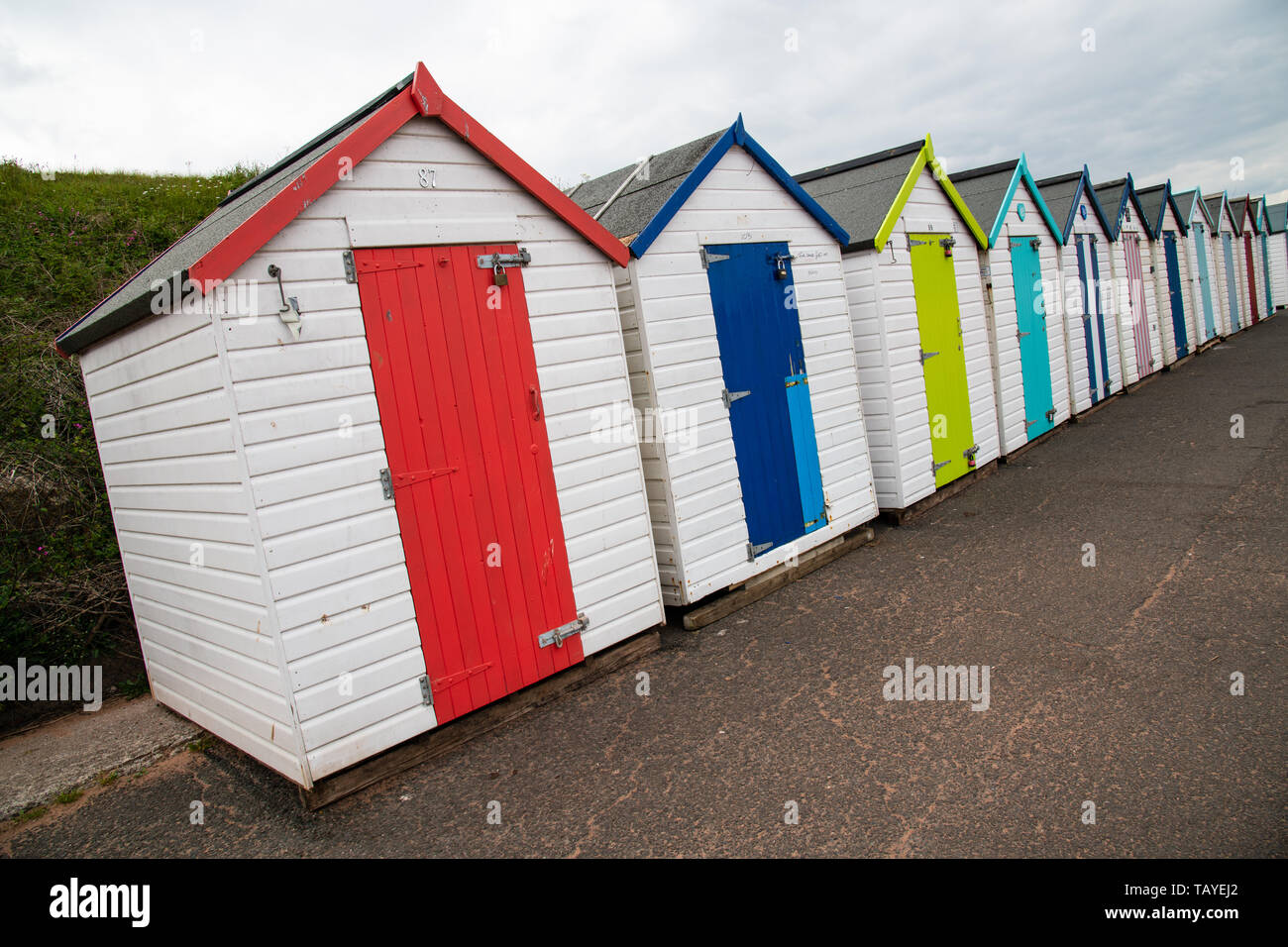 Colorful beach huts with moody sky on Goodrington sands beach, Devon ...