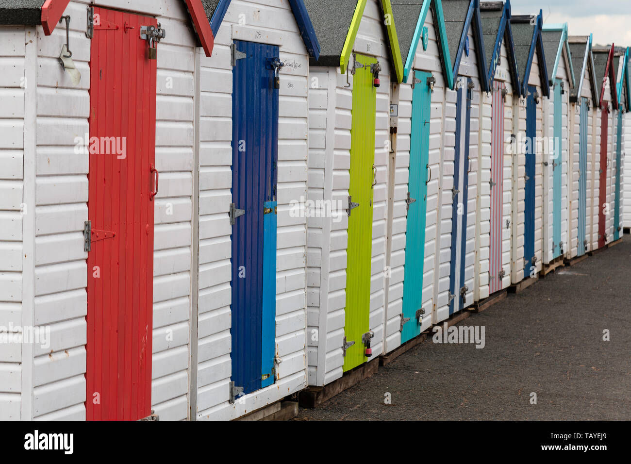 Colorful beach huts with moody sky on Goodrington sands beach, Devon ...
