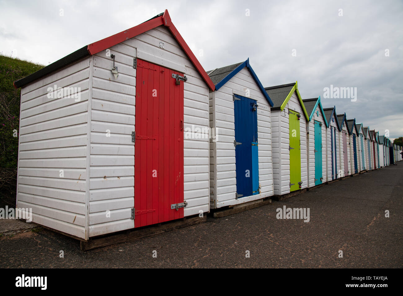Colorful beach huts with moody sky on Goodrington sands beach, Devon ...