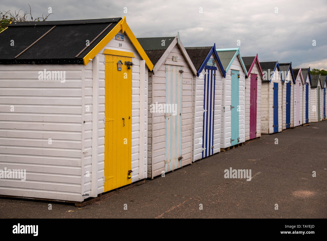 Colorful beach huts with moody sky on Goodrington sands beach, Devon ...