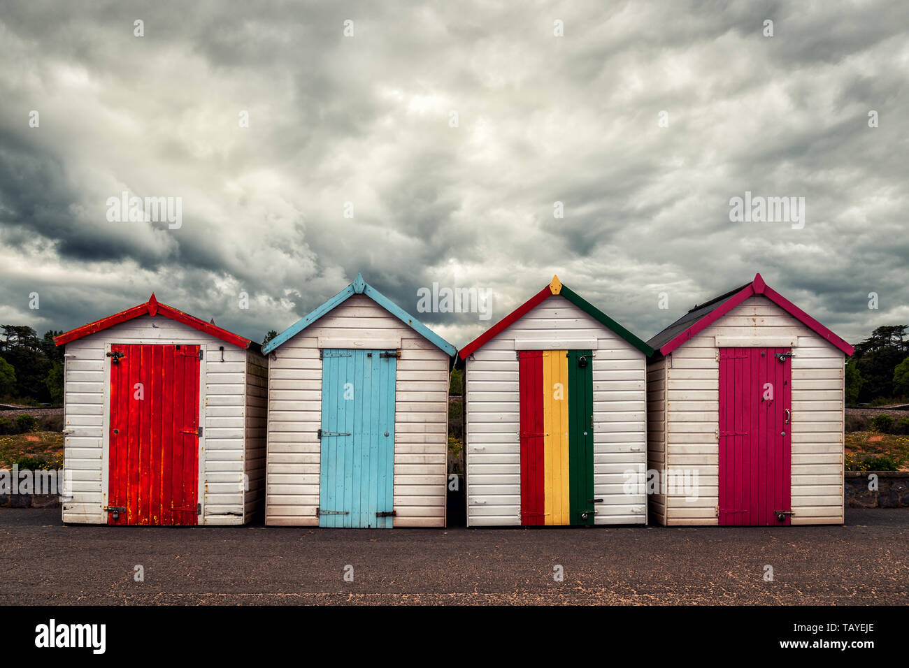 Colorful beach huts with moody sky on Goodrington sands beach, Devon ...