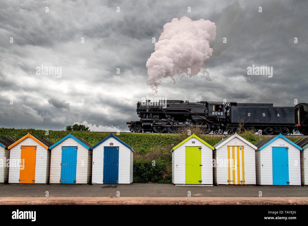 Colorful beach huts with moody sky on Goodrington sands beach, Devon ...