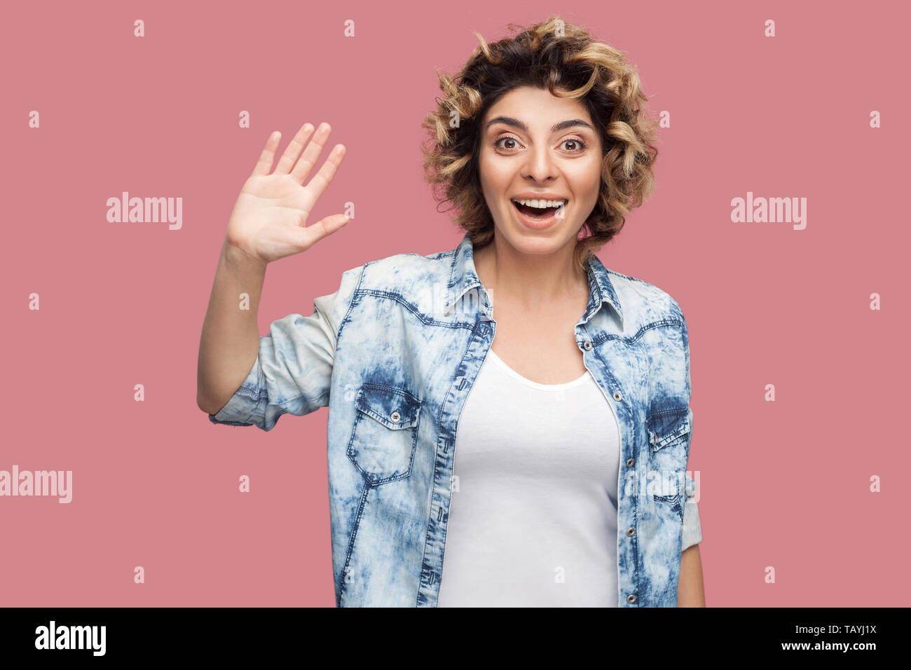 Hi. Portrait of surprised happy young woman with curly hairstyle in ...