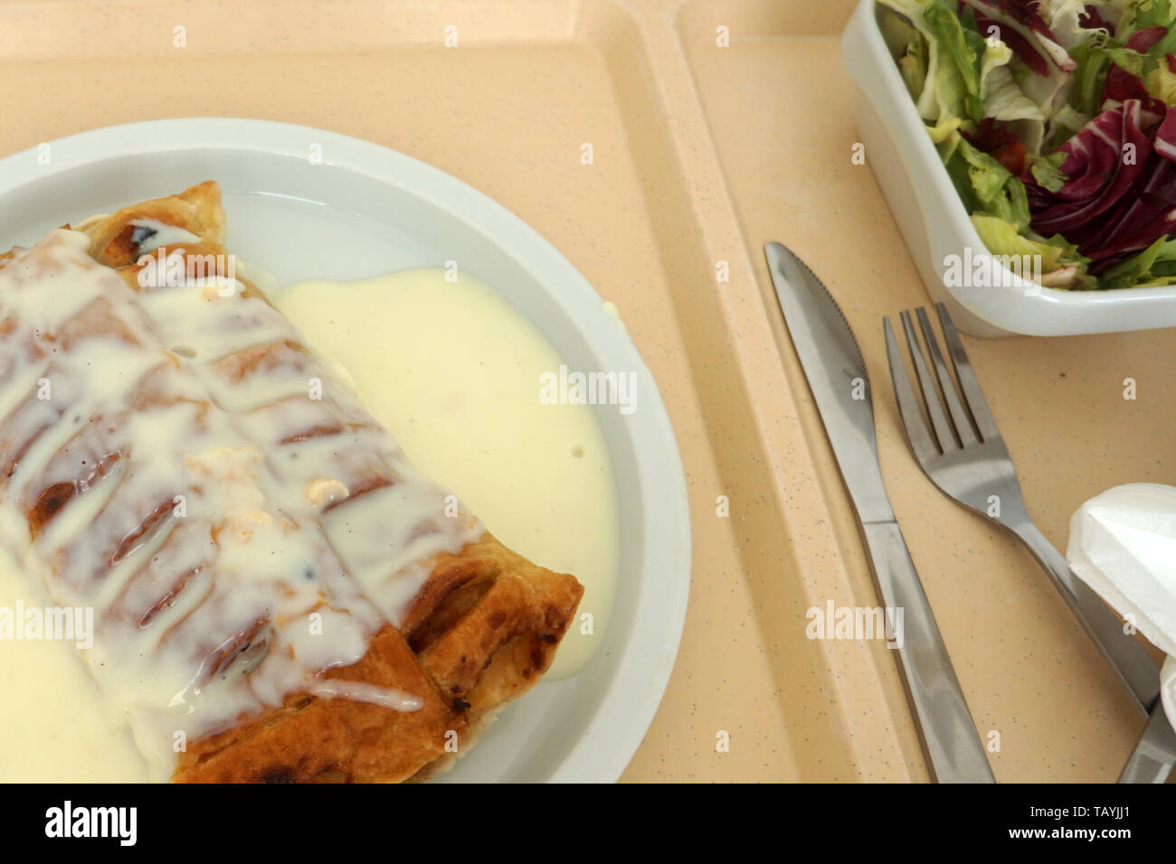 Delicious apple strudel with custard and fruit salad in a canteen in ...