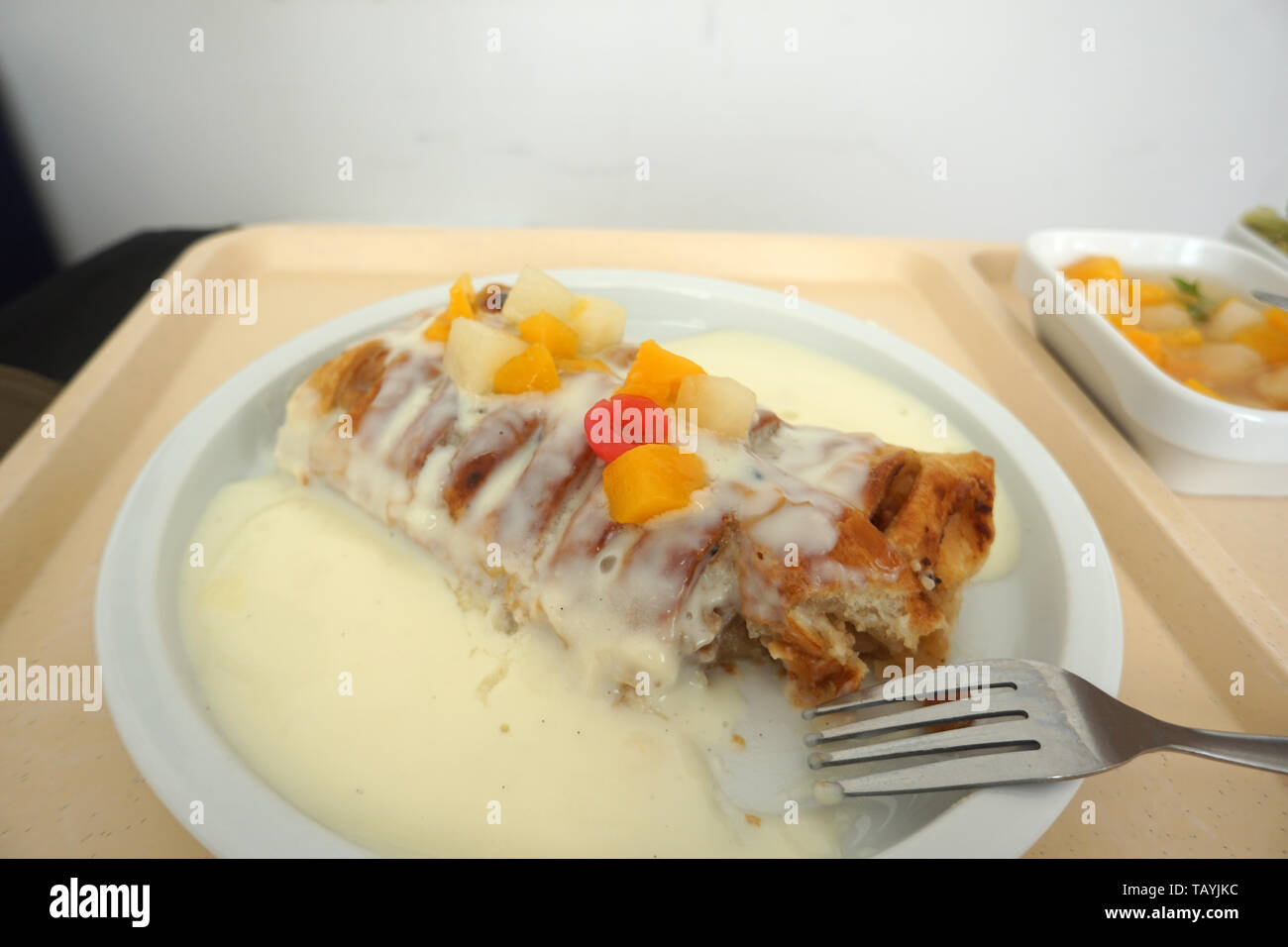 Delicious apple strudel with custard and fruit salad in a canteen in ...