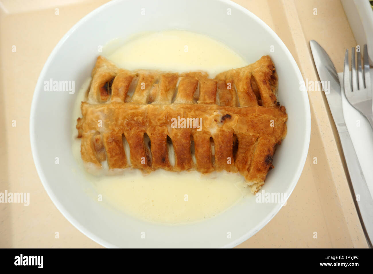 Delicious apple strudel with custard and fruit salad in a canteen in ...
