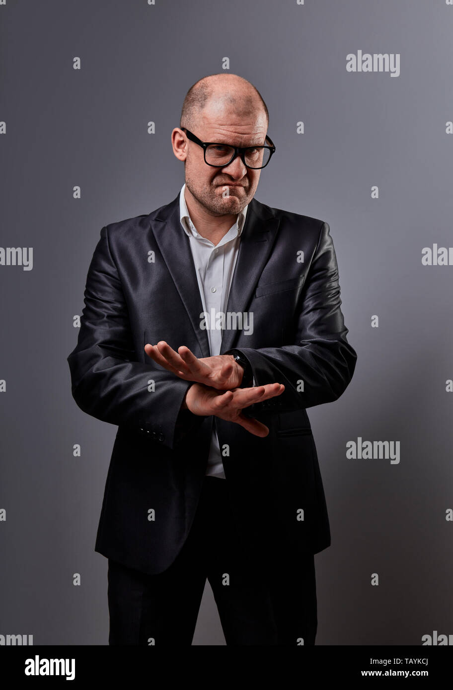 Unhappy busuness man in black suit and glasses showing the palm ...
