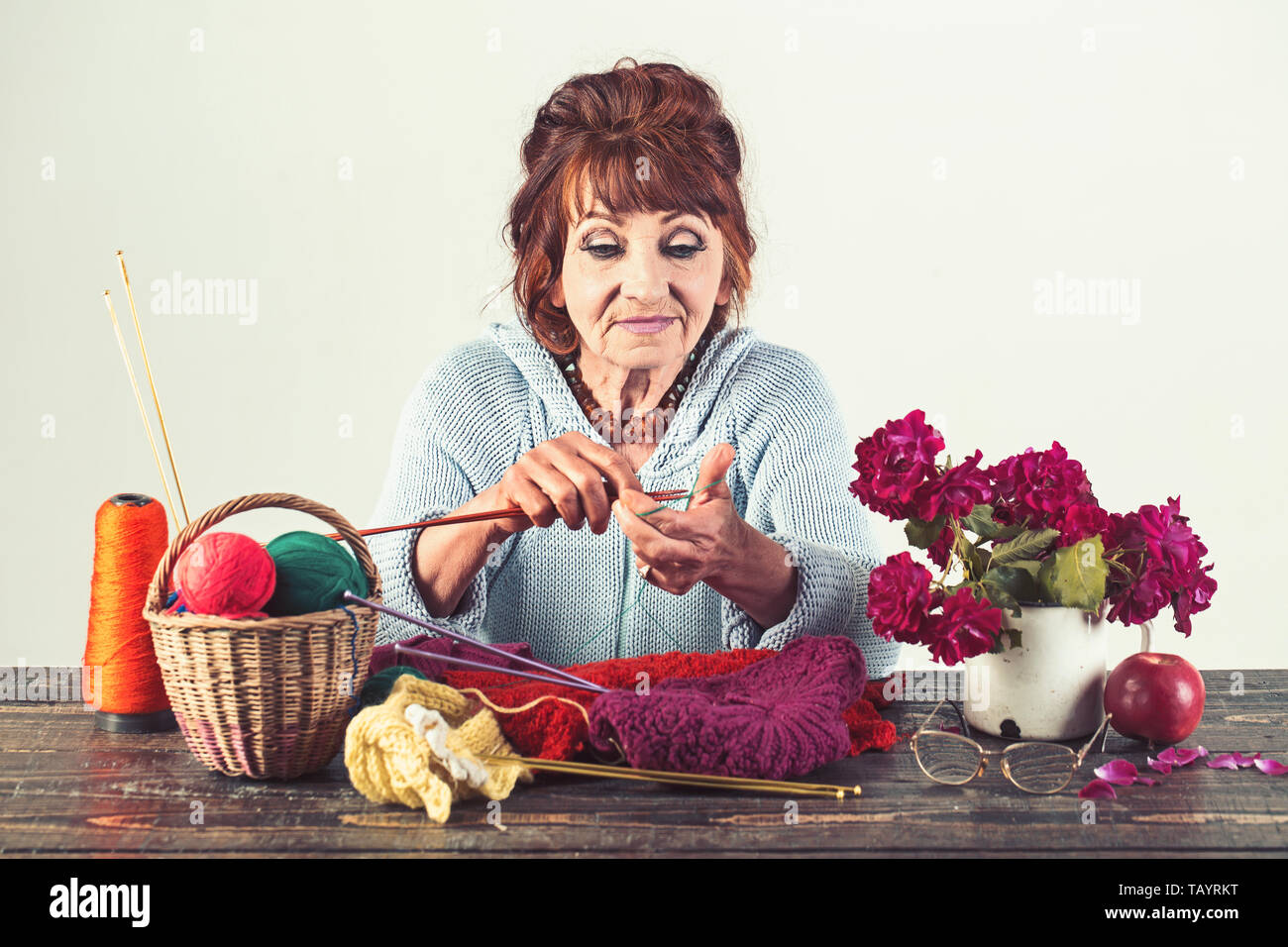 Pension and retirement, old age. Old woman knitting socks from colorful ...