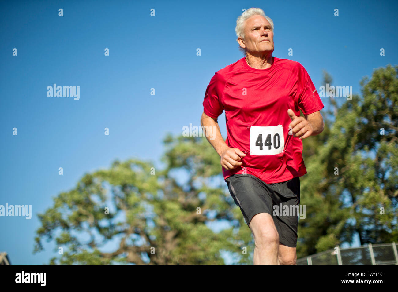 Active senior man running on a sports track Stock Photo - Alamy