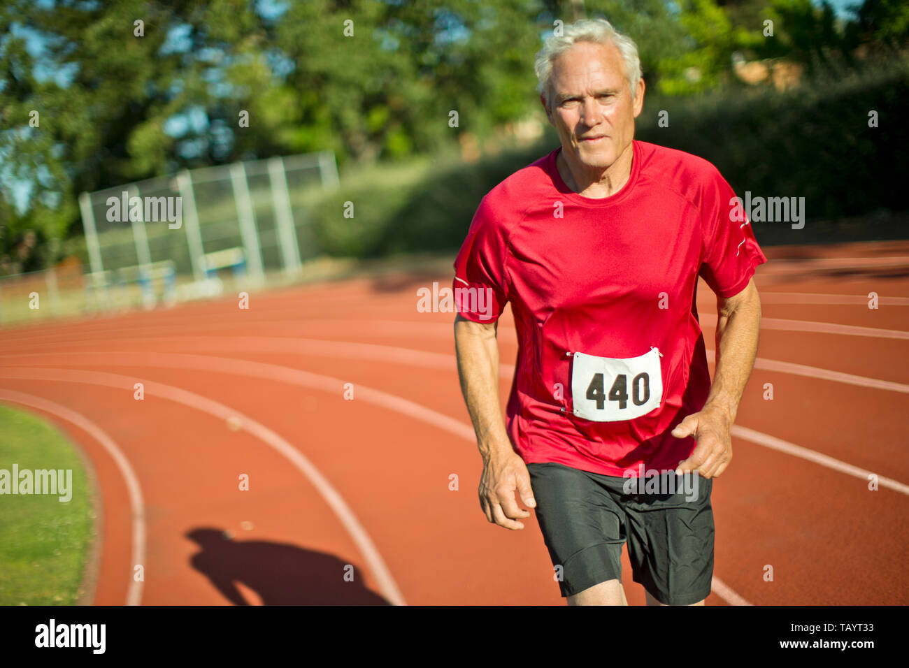 Active senior man running on a sports track Stock Photo - Alamy