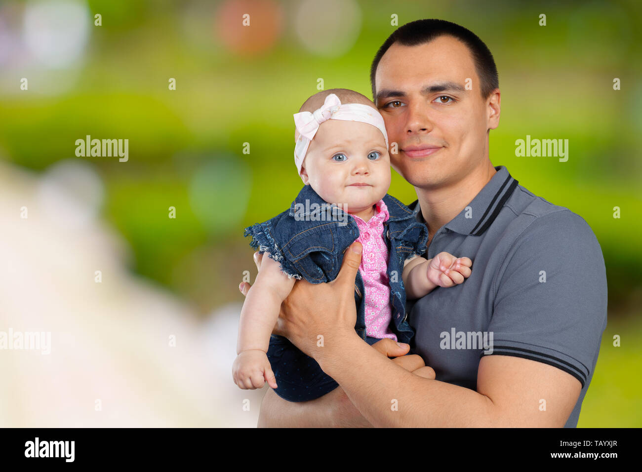 Happy young man holding a baby Stock Photo - Alamy