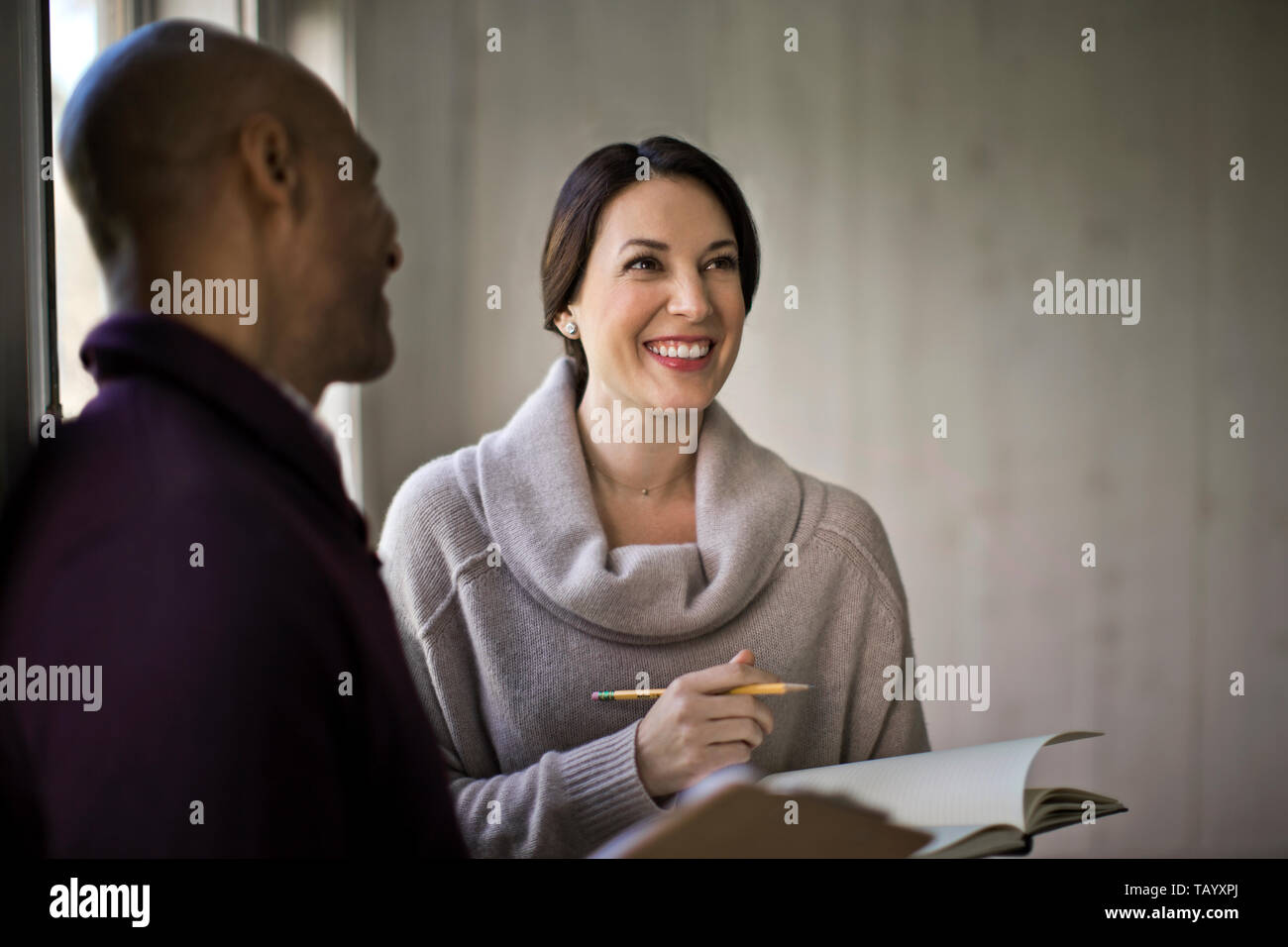 Two colleagues smiling and working Stock Photo - Alamy