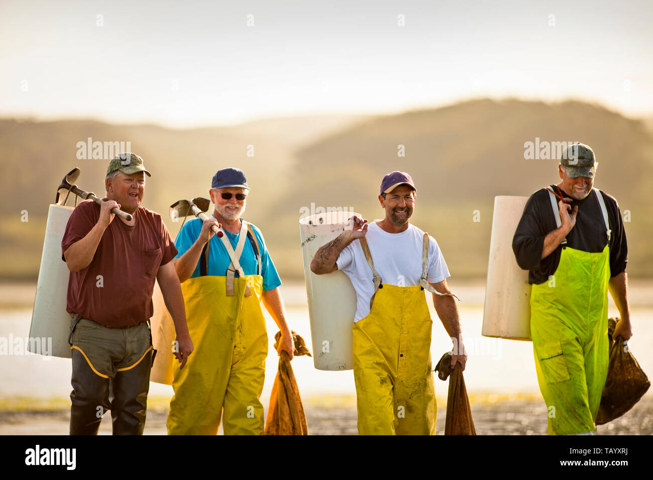 Group of fisherman on the beach with bags of shellfish Stock Photo - Alamy