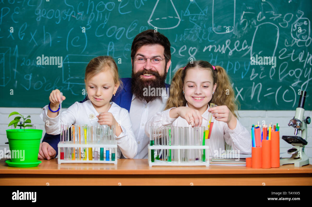 Research studies. Science teacher and pupils doing research work ...