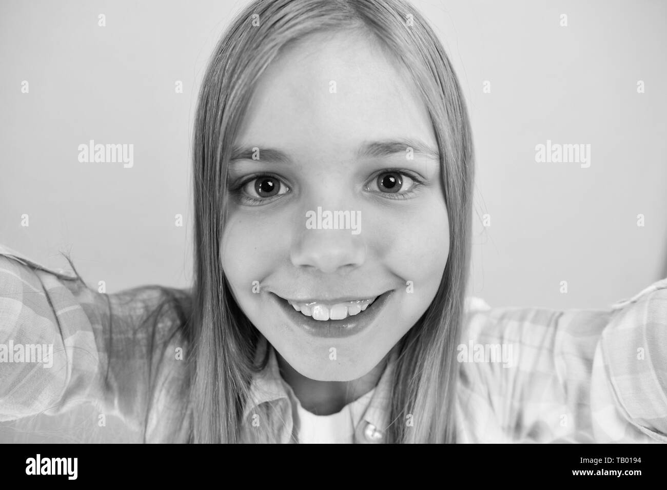 Let me take selfie. Child girl hold smartphone takes photo. Child kid ...