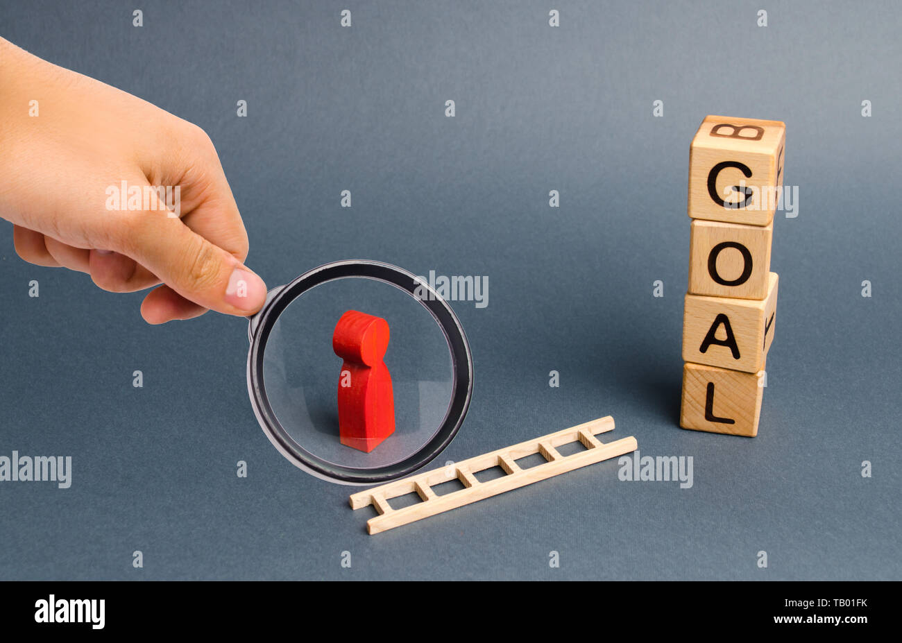 Magnifying glass is looking at a red figure of a man stands near fallen ...