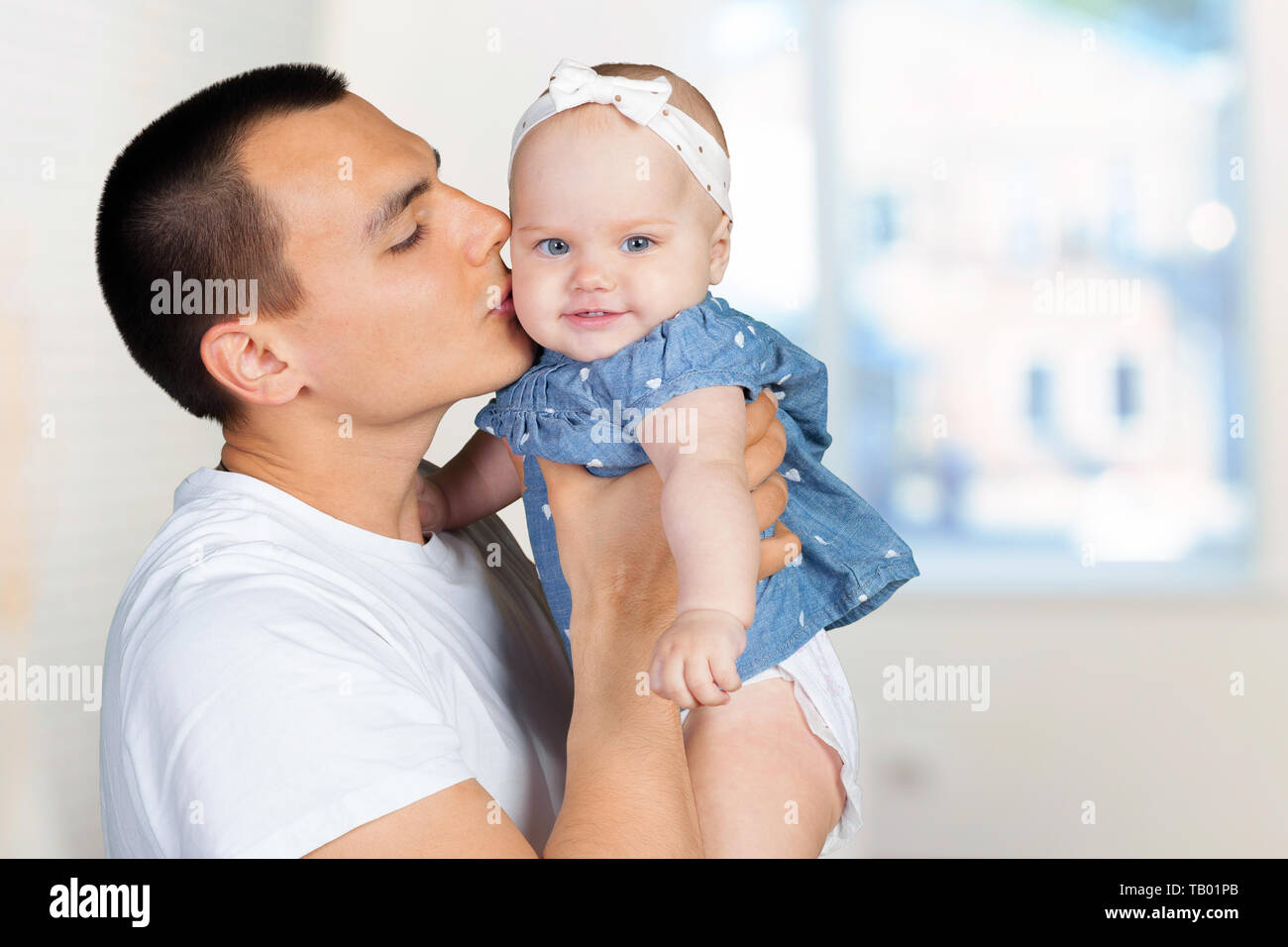 Happy young man holding a baby Stock Photo - Alamy