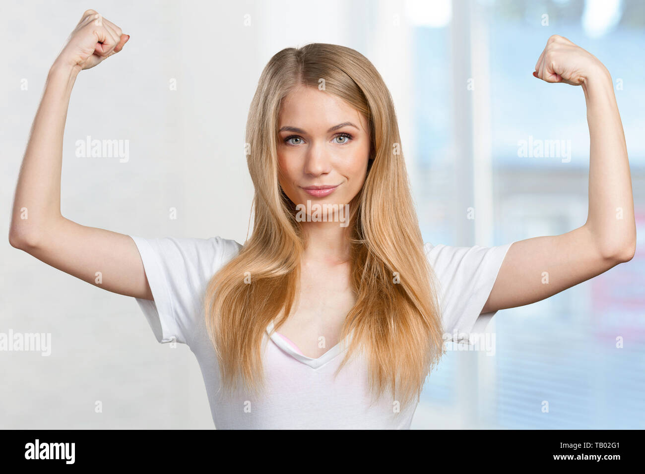 Pretty young blonde woman throwing her arms up into the air in ...