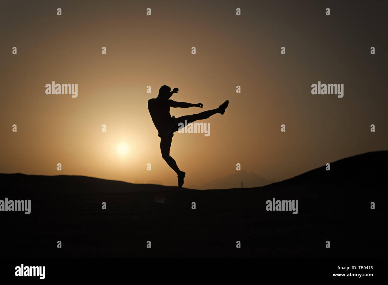 Hit your goal. Silhouette man motion jump in front of sunset sky ...