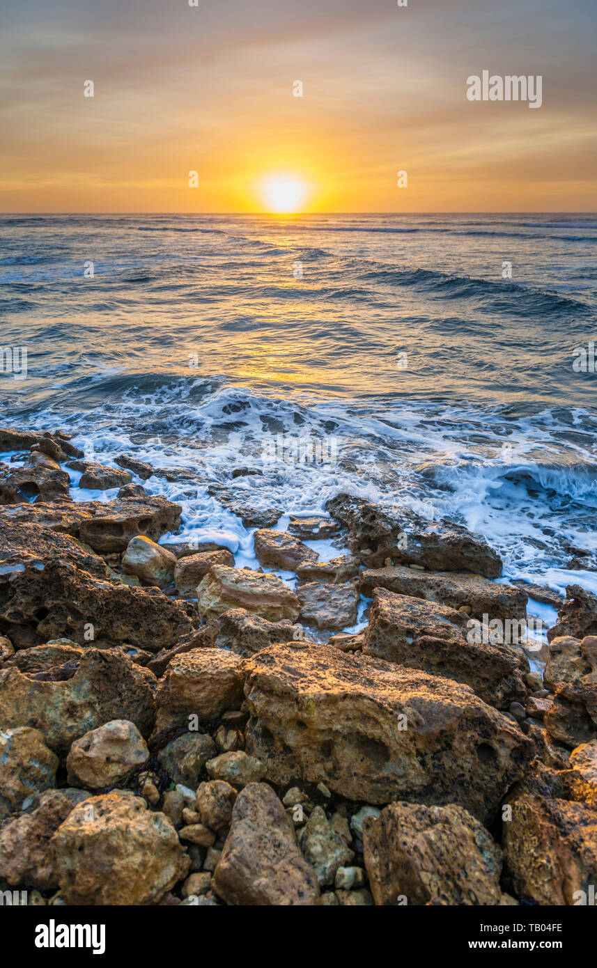 Sunset or sunrise over a rugged coastline Stock Photo - Alamy