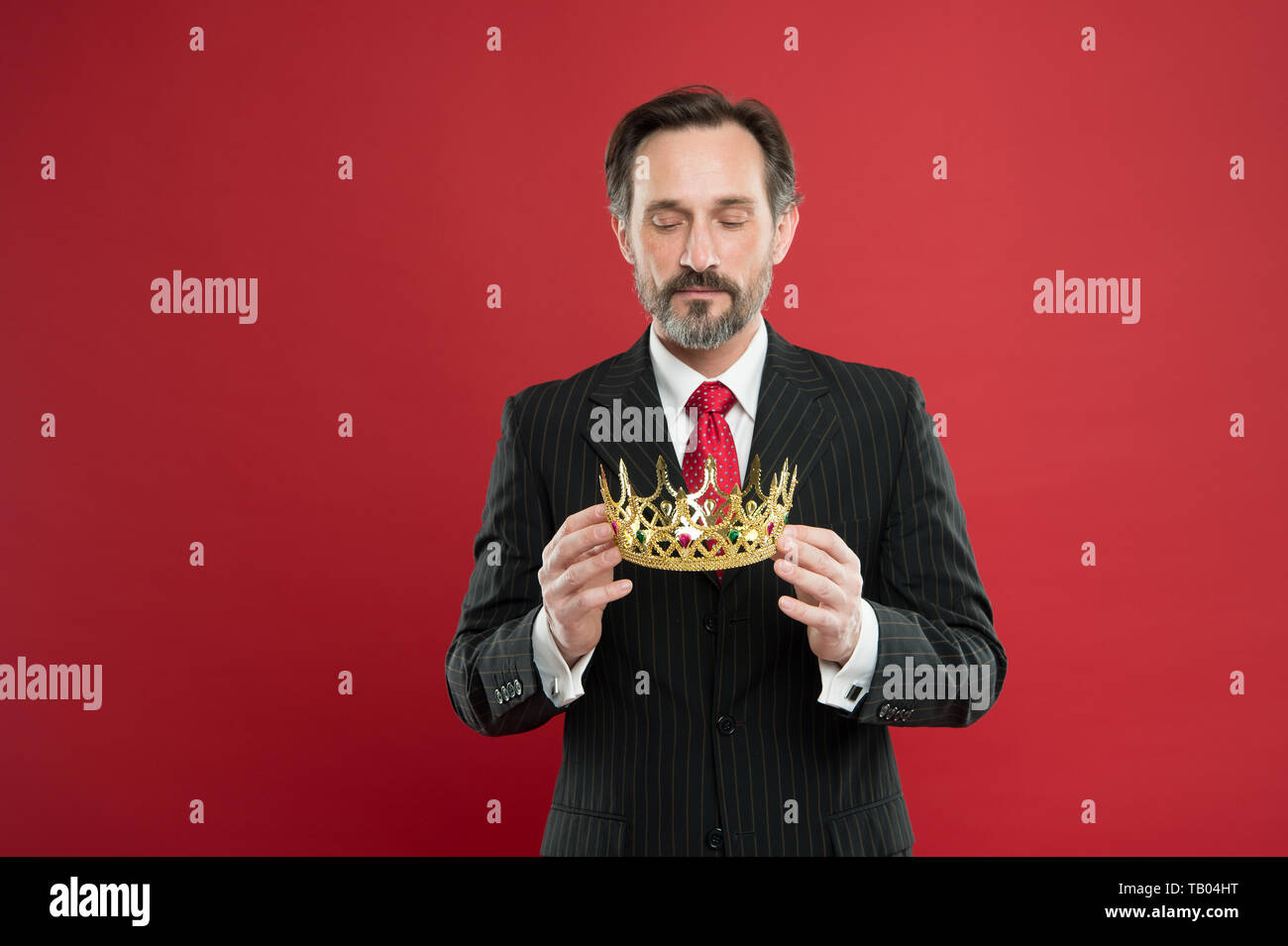 Monarchy family traditions. Man bearded guy in suit hold golden crown ...