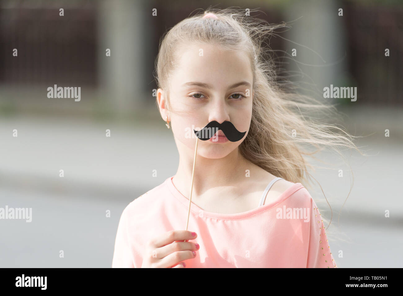 Loving her mustache. Little girl with fake mustache. Cute child holding ...