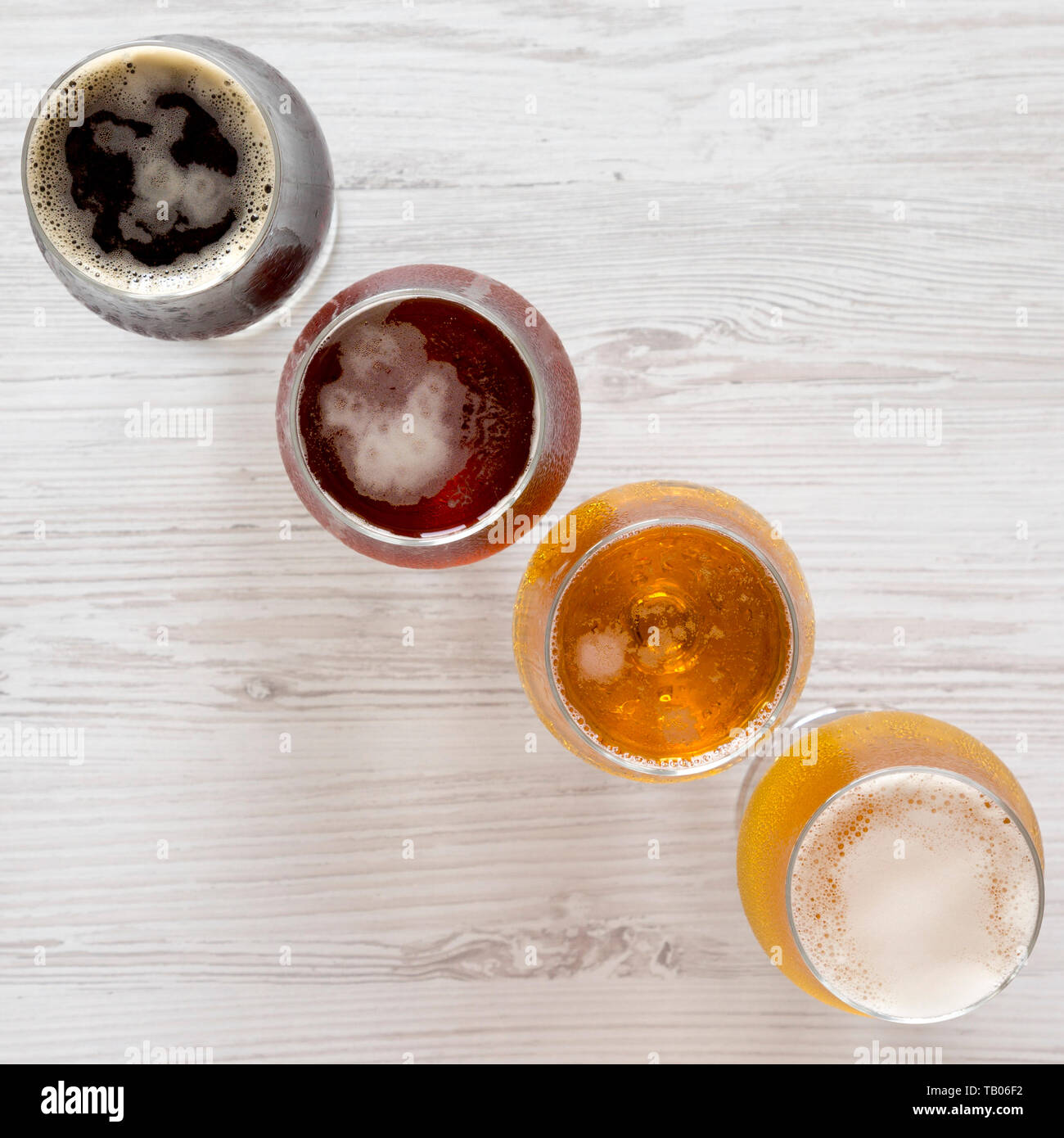 Flight of beers on a white wooden table, top view. Overhead, from above ...