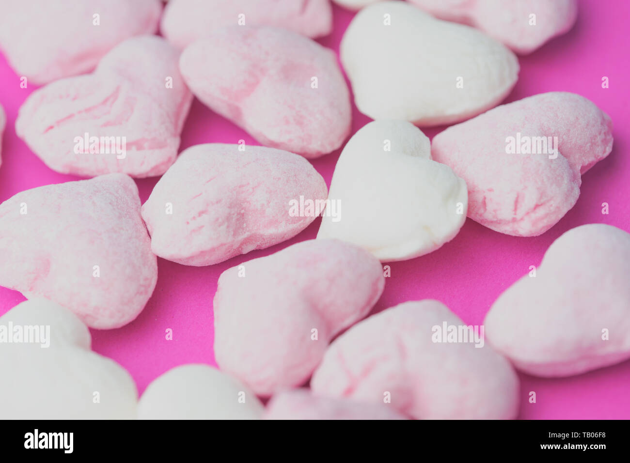 background picture with heart-shaped hard candies on a pink background ...