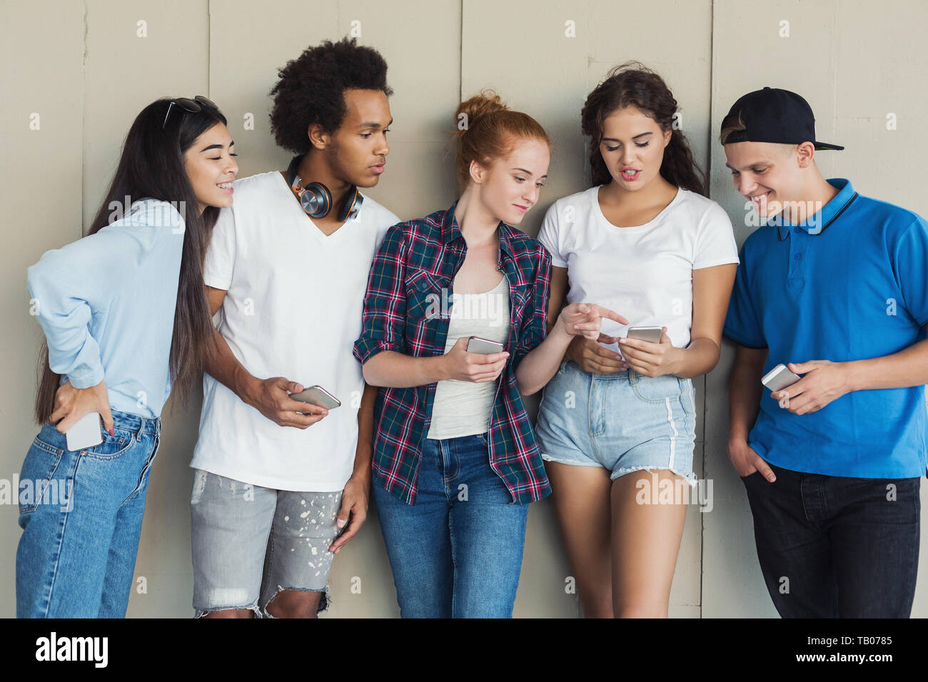 Group Of Teenagers Sharing Text Message On Mobile Phones Stock Photo ...