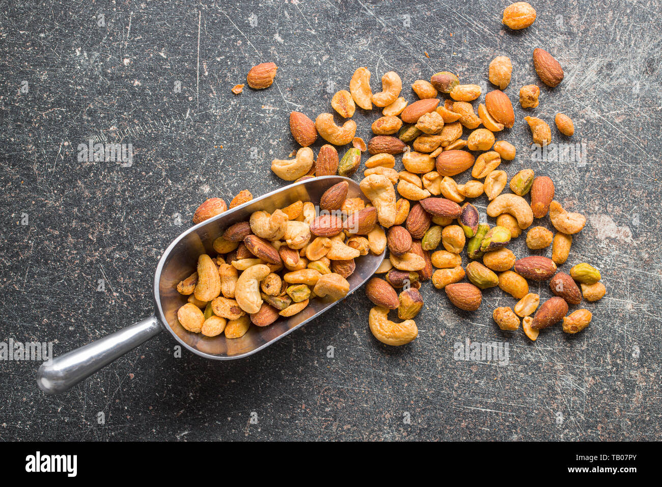 Spicy flavoured nuts. Mix of nuts in scoop. Top view Stock Photo - Alamy
